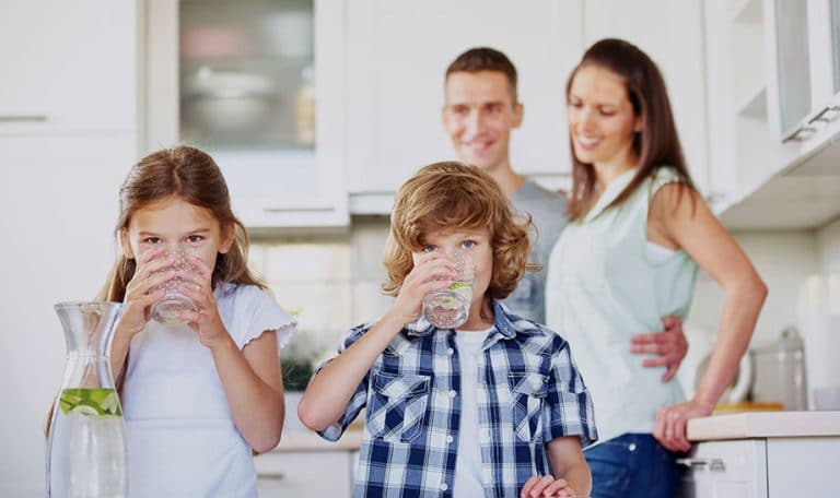 girl-boy-drinking-family-in-kitchen - Hellenbrand